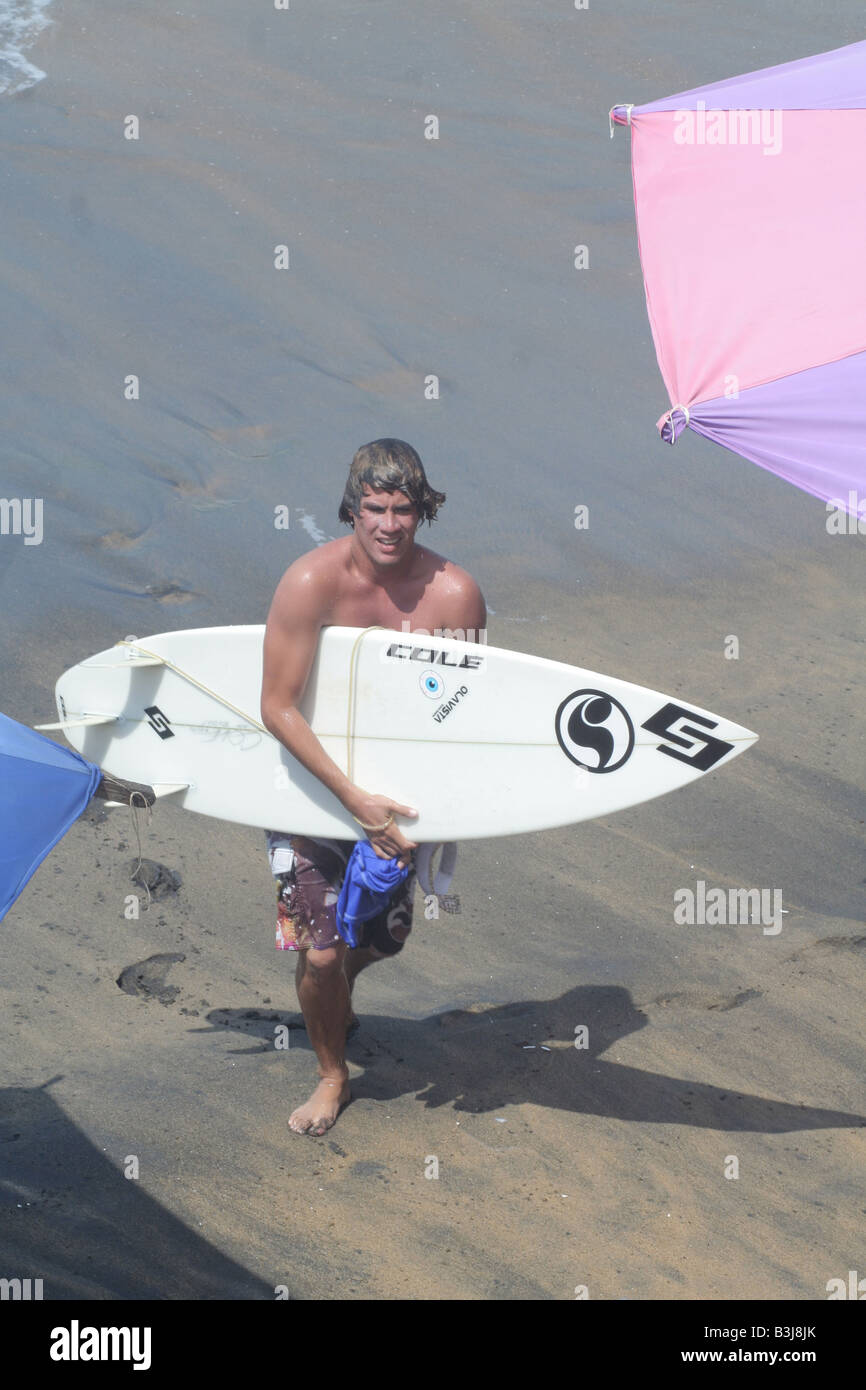 surfer getting out of the water with his board walking Stock Photo - Alamy