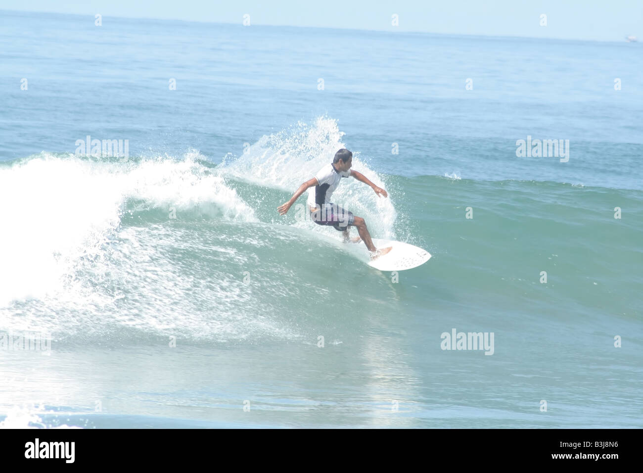 surfer riding a perfect wave and doing tricks Stock Photo - Alamy