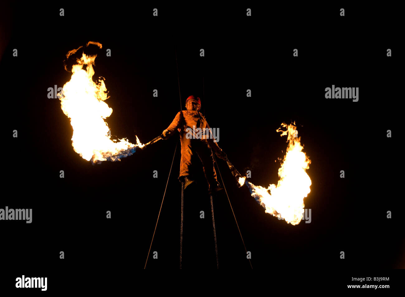 Suspended man shooting fire Stock Photo - Alamy