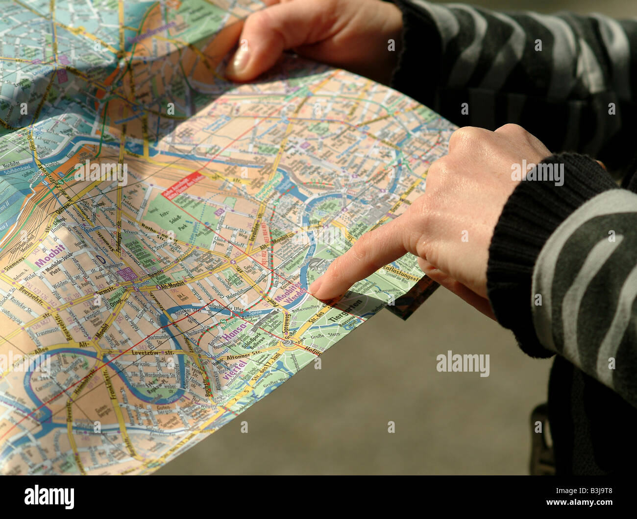 a female tourist points out something on a map of Berlin Stock Photo ...
