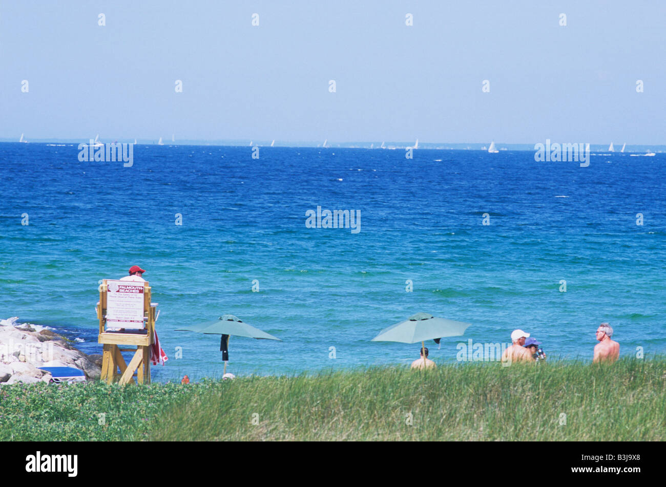 Blue green water of a Cape Cod beach with umbrellas, lifeguard chair ...