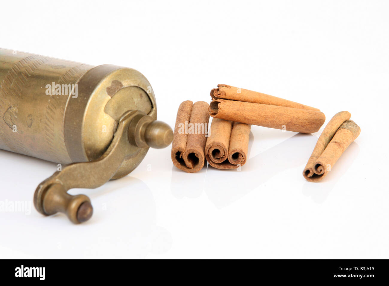 antigue kitchen hand mill with cinnamon detail isolated Stock Photo - Alamy
