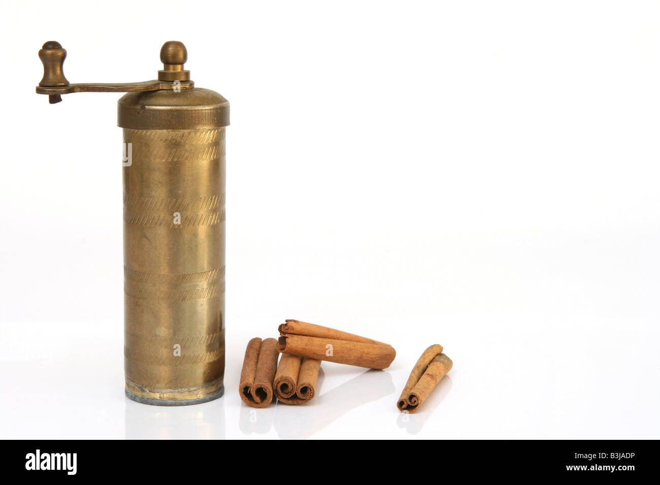 antigue kitchen hand mill with cinnamon isolated on white background ...