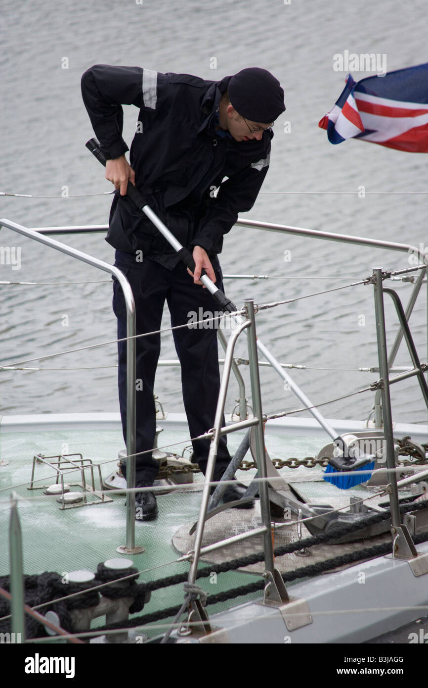 Royal Navy sailor mopping the deck of HMS Ranger at the Tall Ships race ...