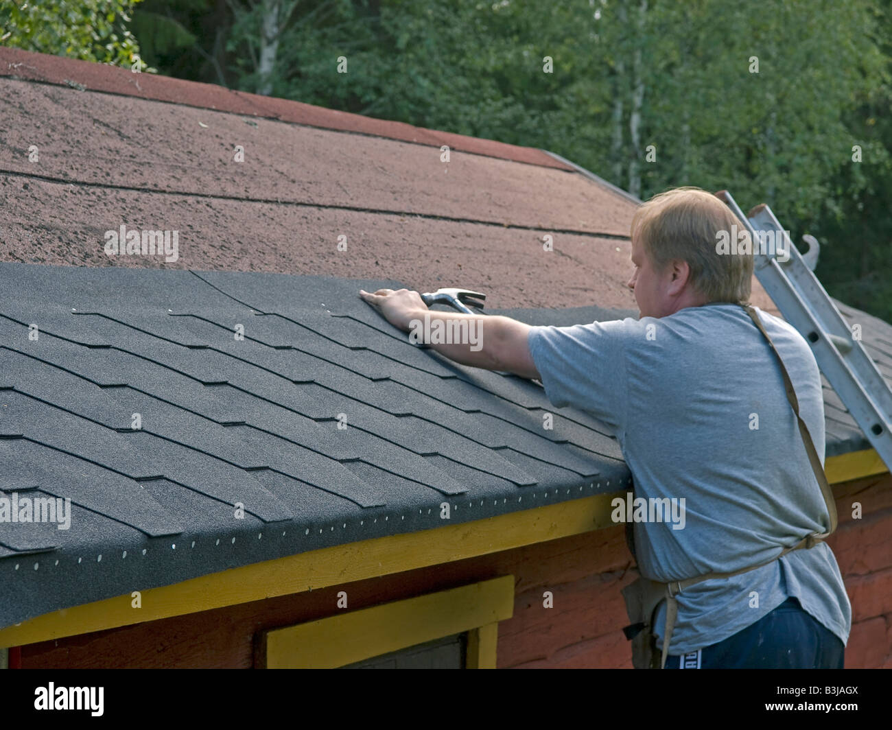 man menting renovating remaking roofing cardboard roofing felt on roof ...