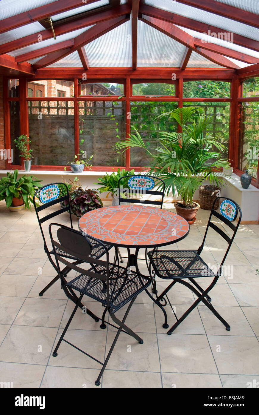 conservatory tables chairs plants room in house next to garden Stock ...