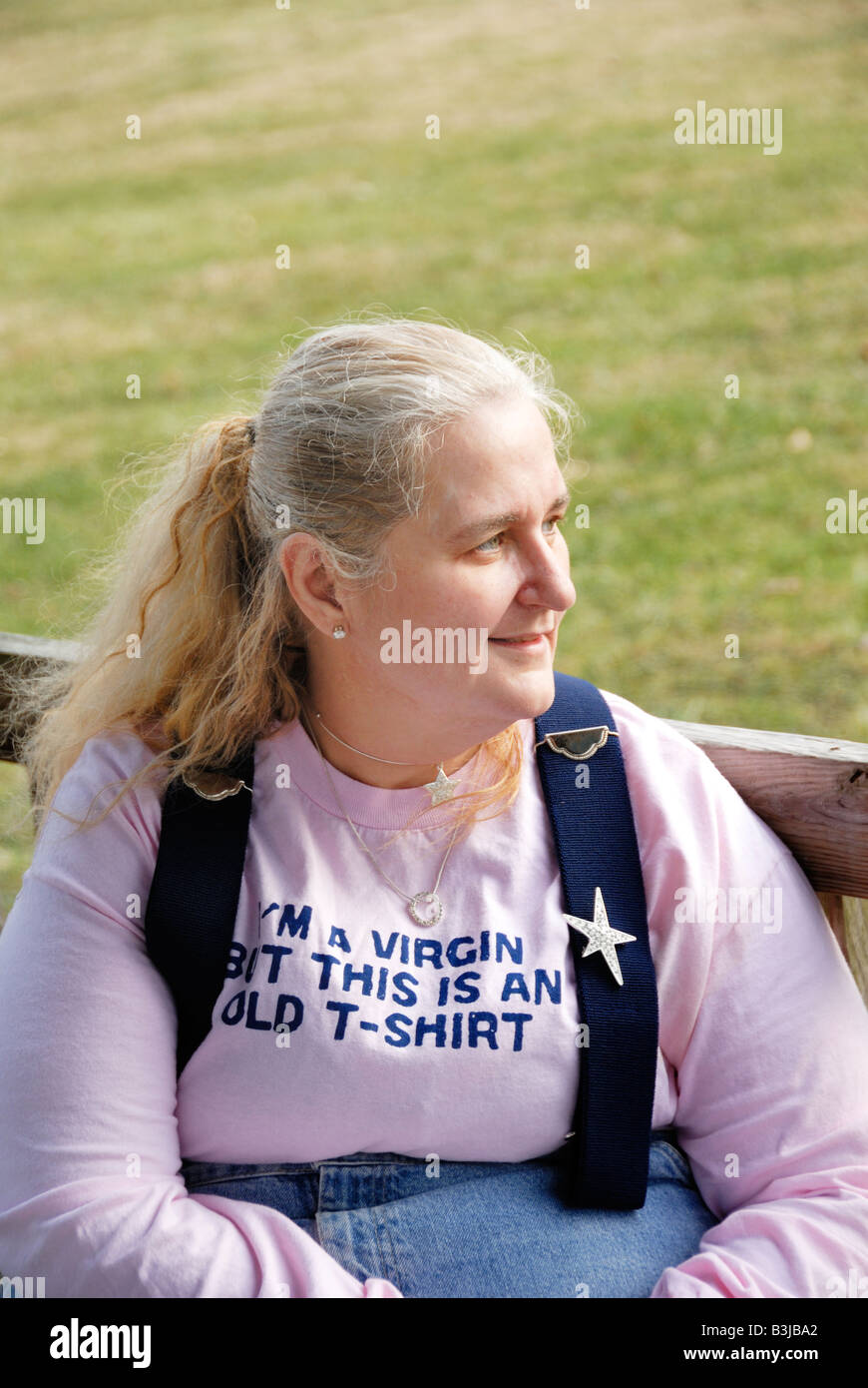 Older woman sitting at park looking off into the distance Stock Photo ...