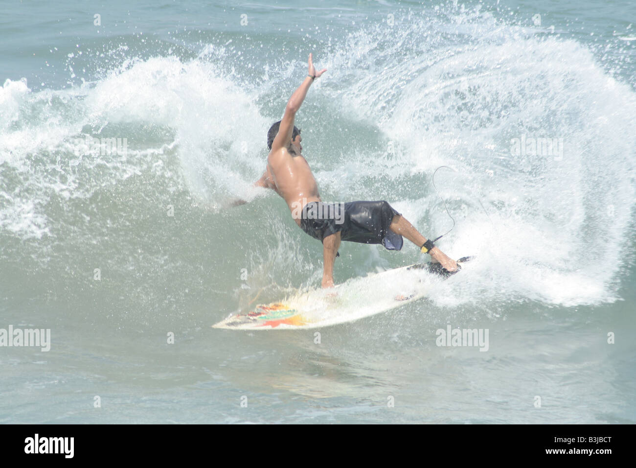 surfer riding a perfect wave and doing tricks Stock Photo - Alamy