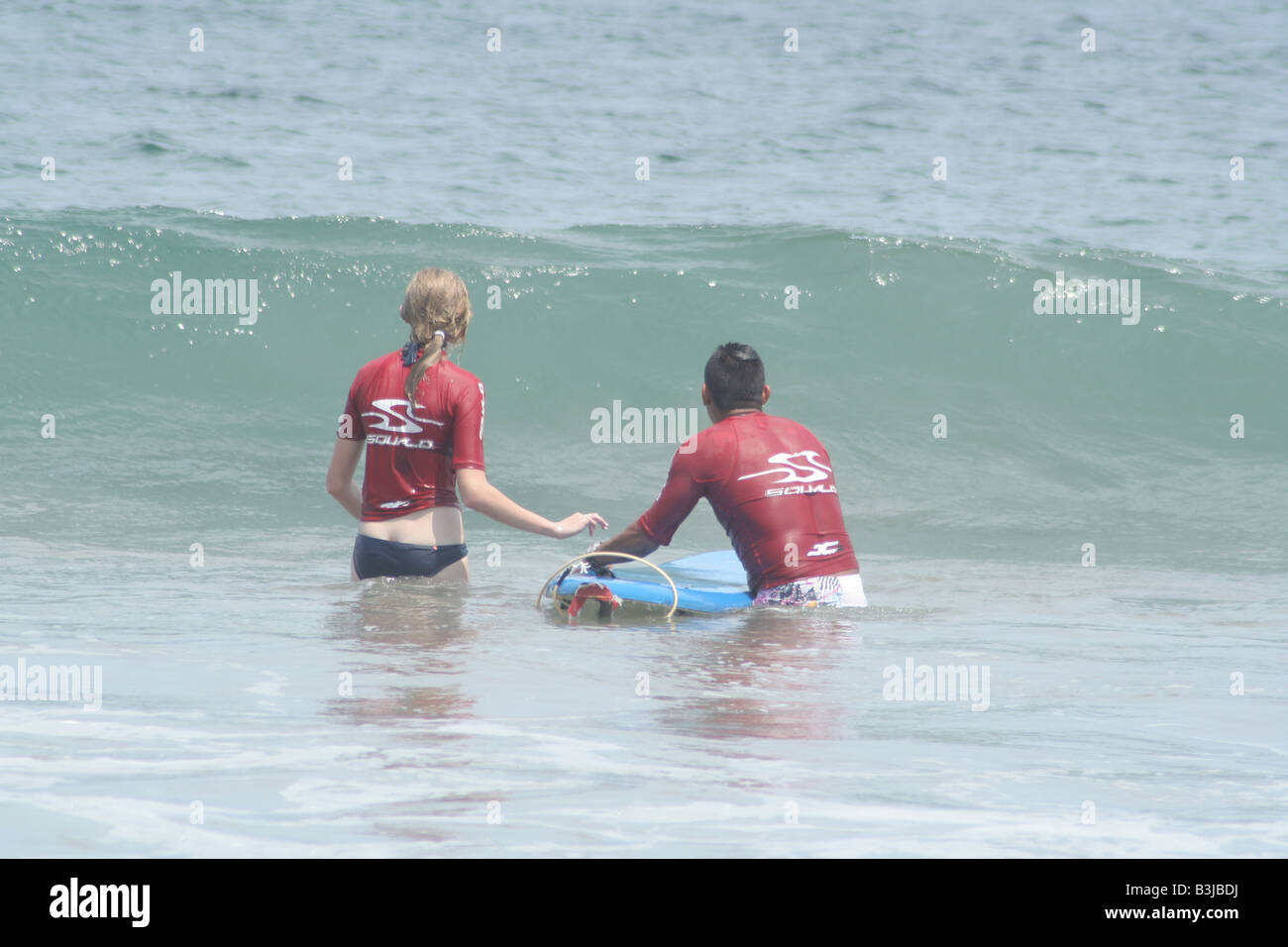 A surf instructor giving classes to a girl Stock Photo - Alamy