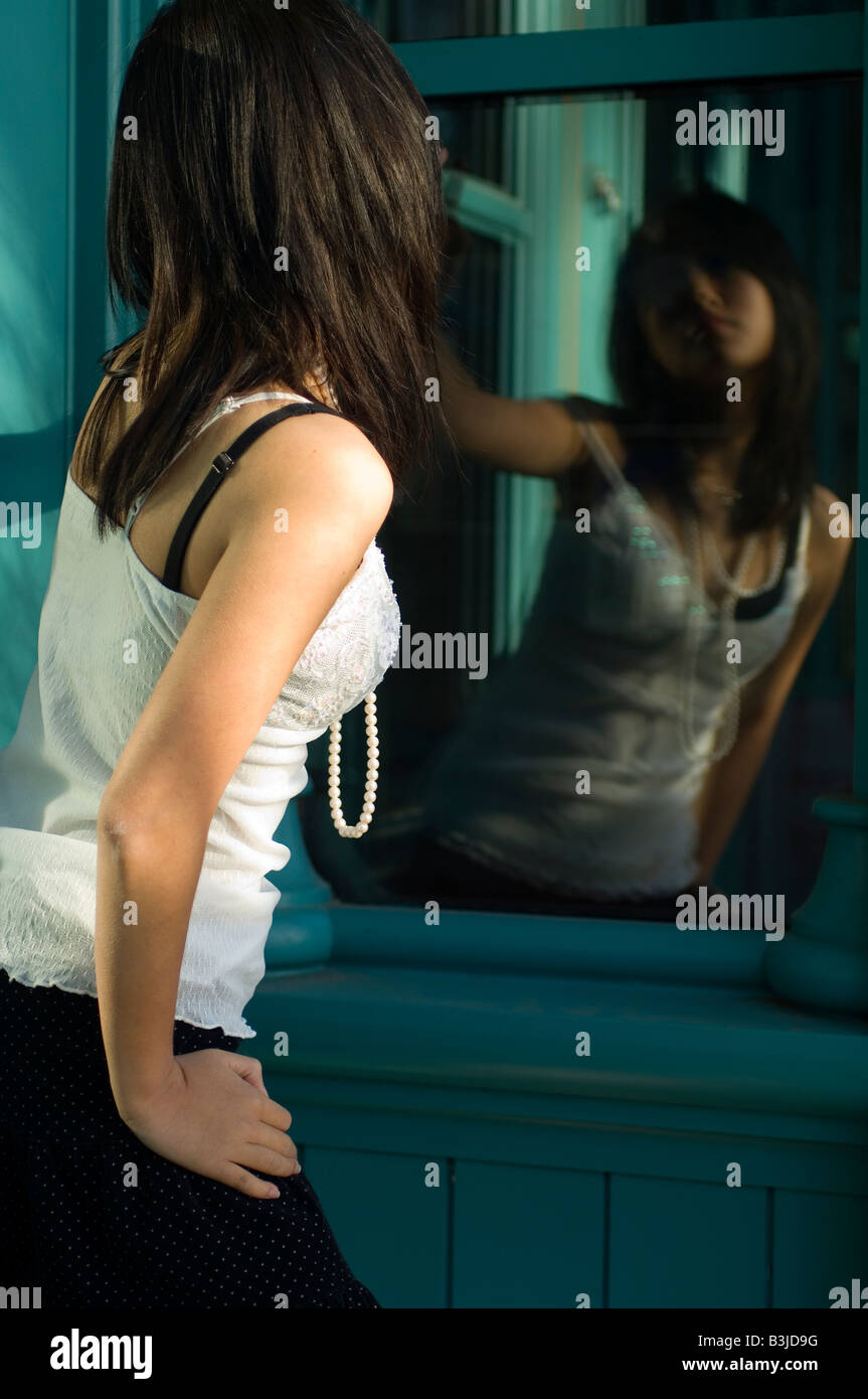 A young asian woman looking at her reflection in a window Stock Photo ...