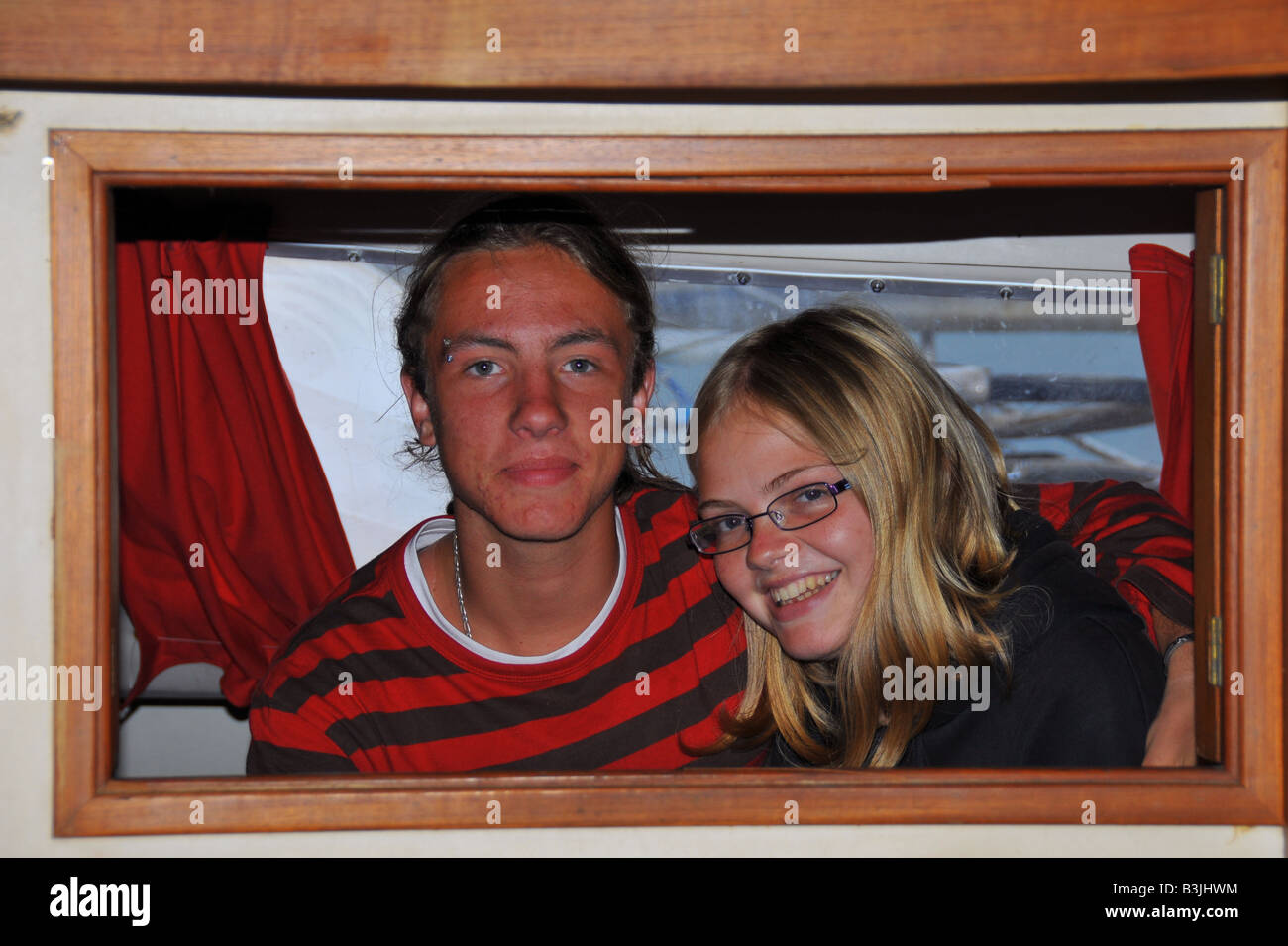 a couple of teenagers laughing in a sailing boat cabin Stock Photo - Alamy