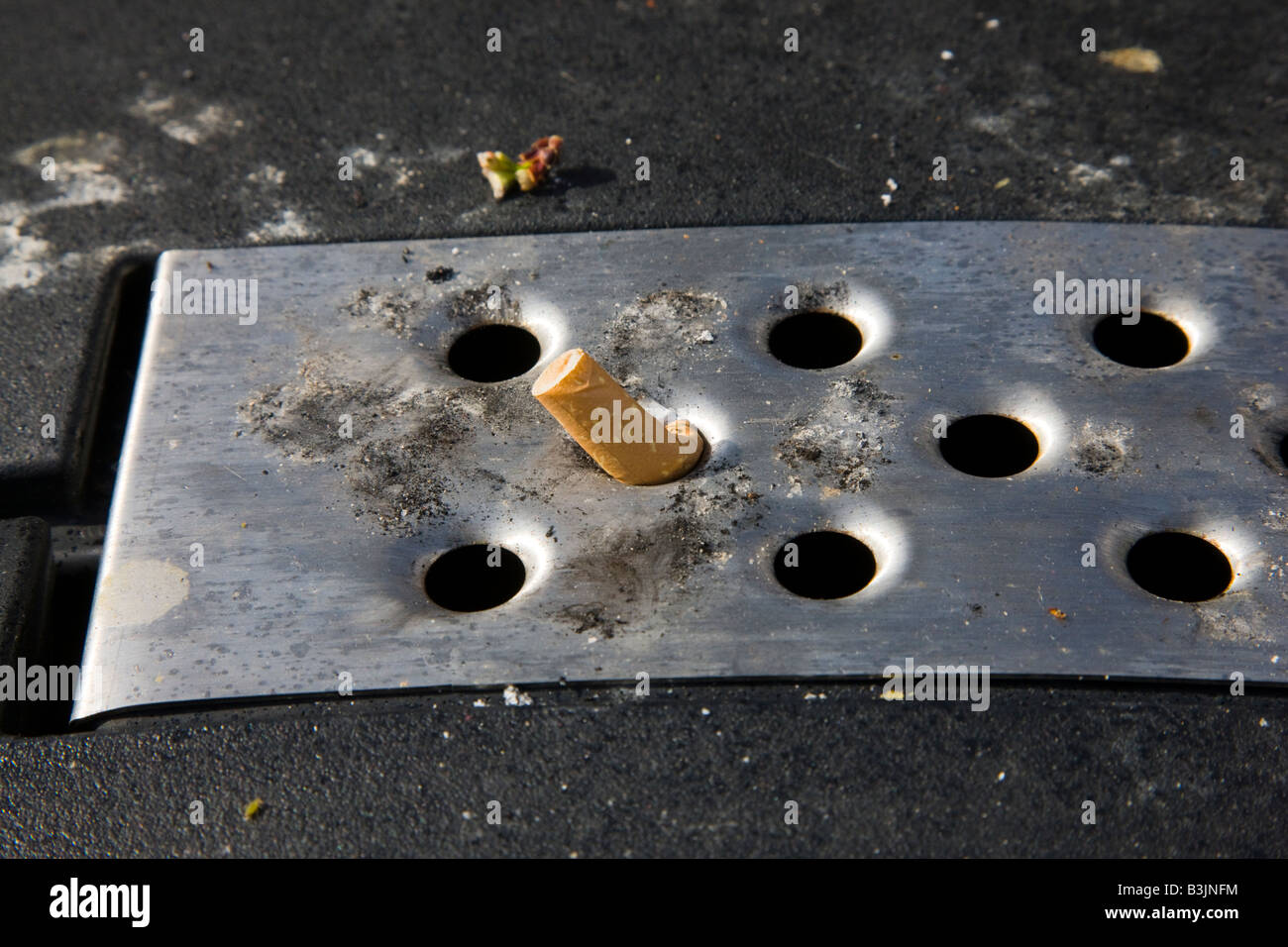 Extinguished cigarettes butt ends on a stainless steel ash tray Stock ...