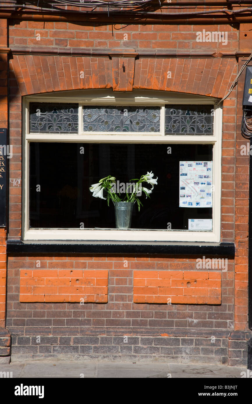 Flowers in a vase placed in a pub window Stock Photo - Alamy