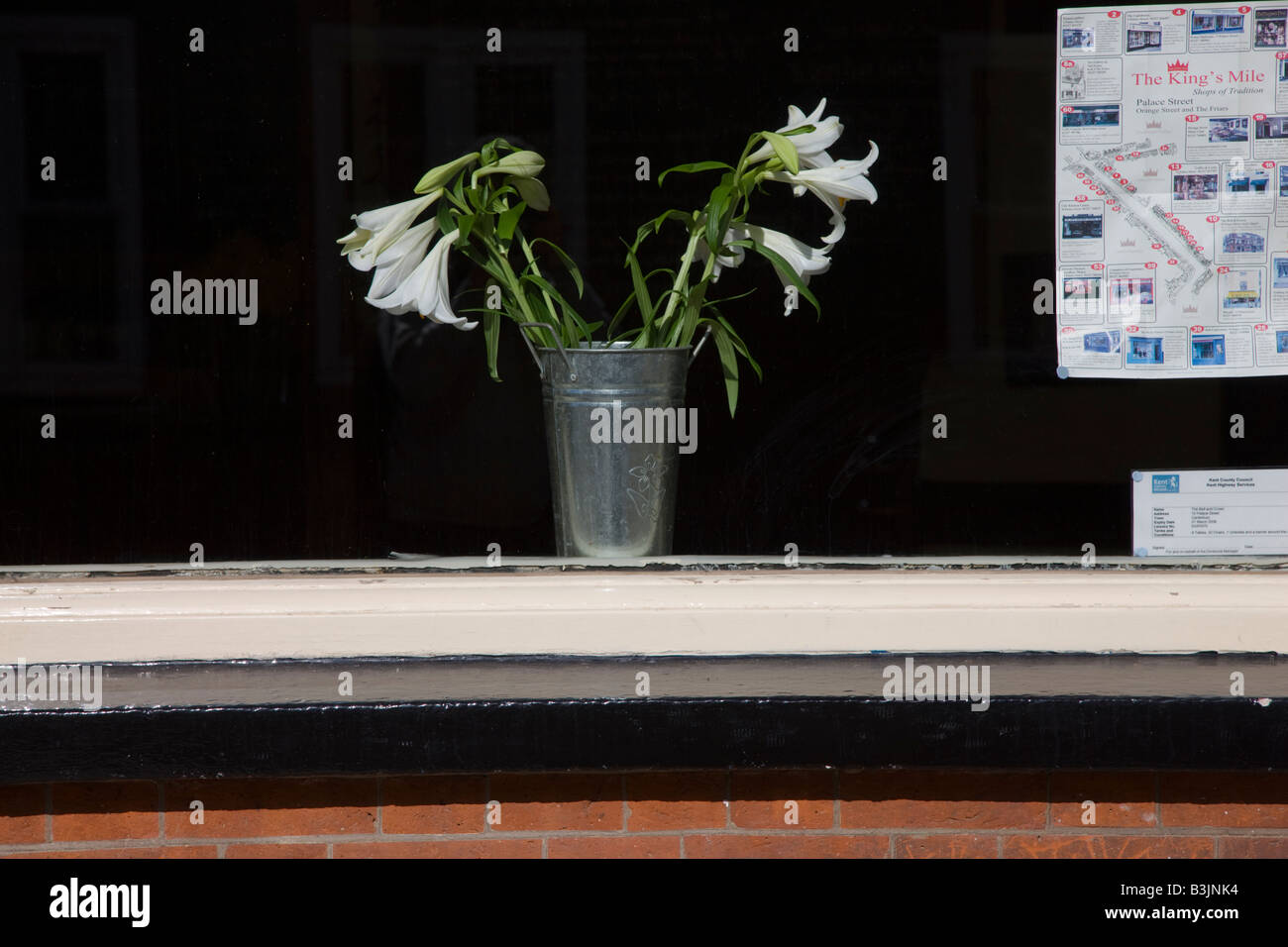 Flowers in a vase placed in a pub window Stock Photo - Alamy