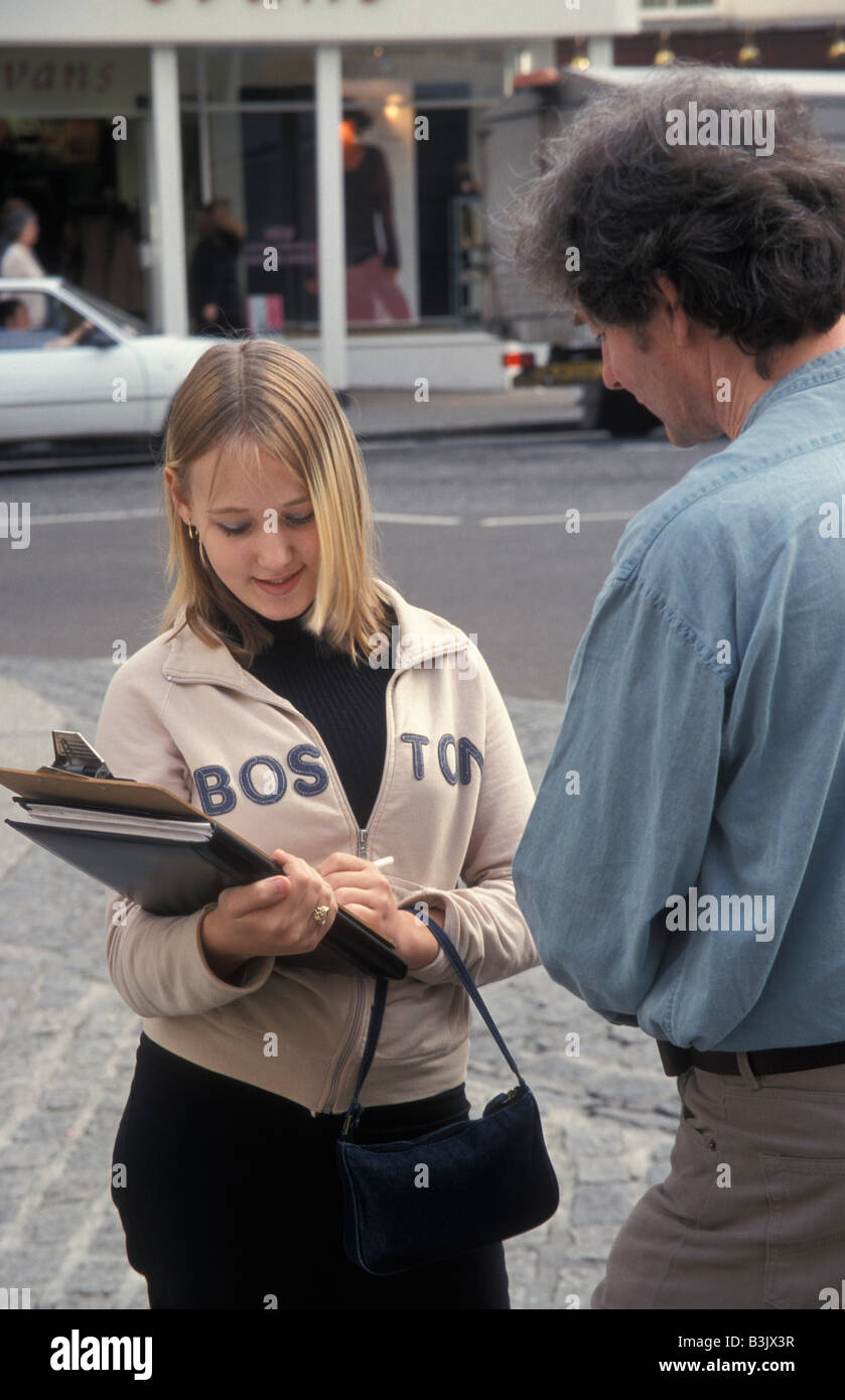 teenage girl interviewing man in town centre Stock Photo - Alamy