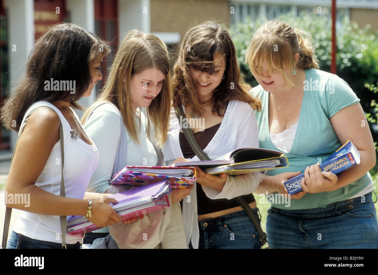 Teenager Education group of girls at college reading Stock Photo - Alamy