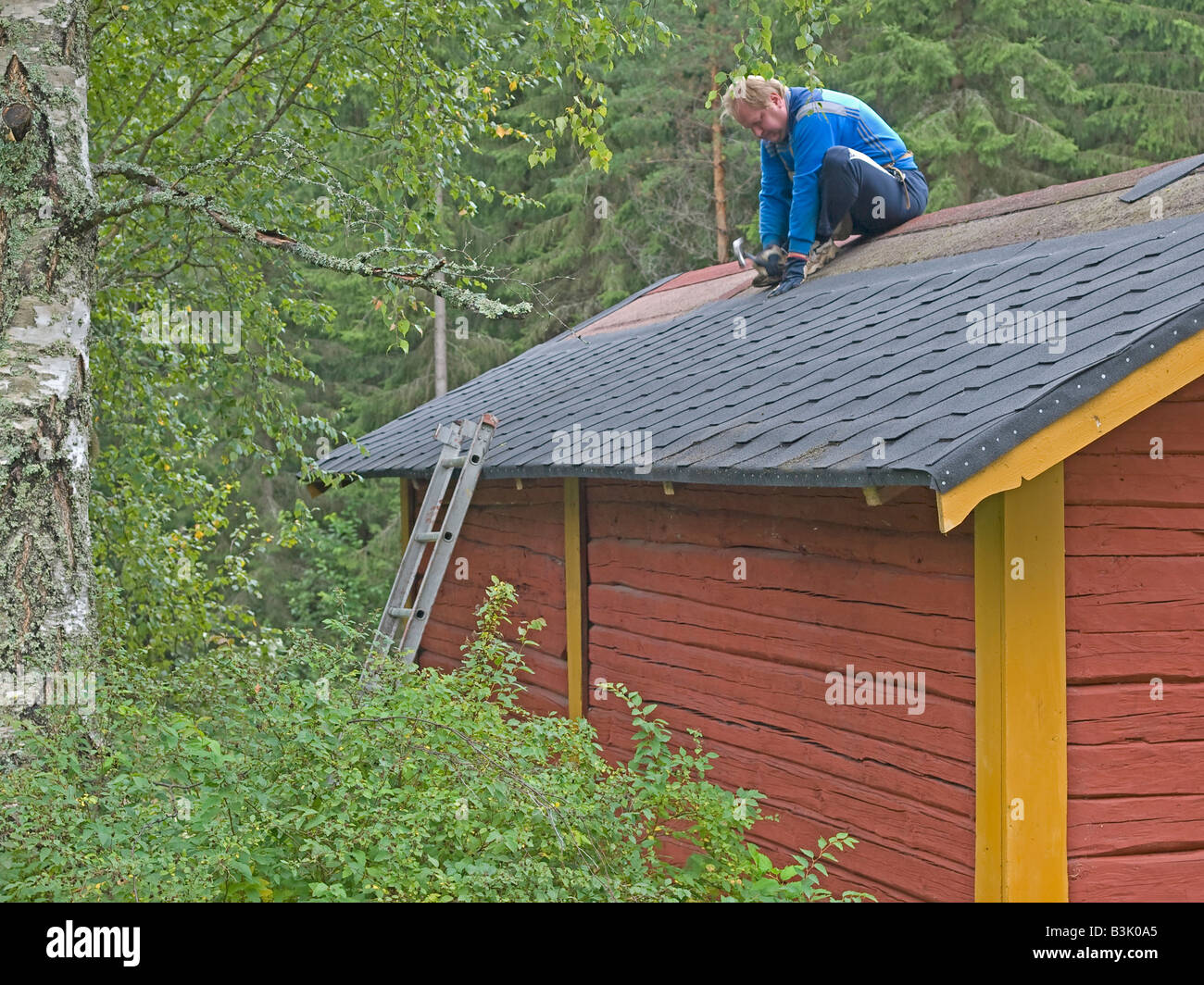 man menting renovating remaking roofing cardboard roofing felt on roof ...