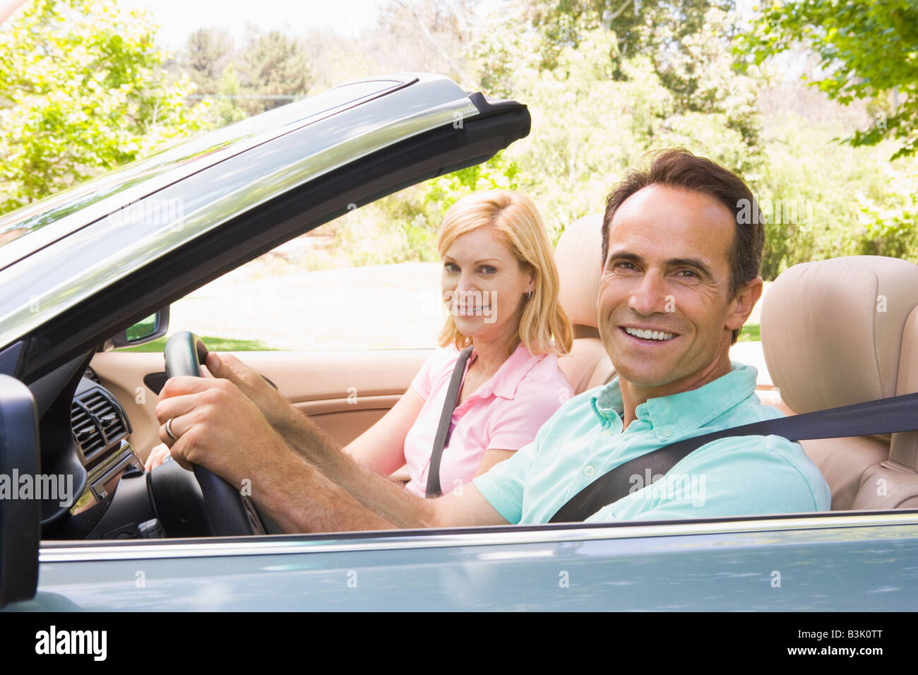 Couple in convertible car smiling Stock Photo - Alamy