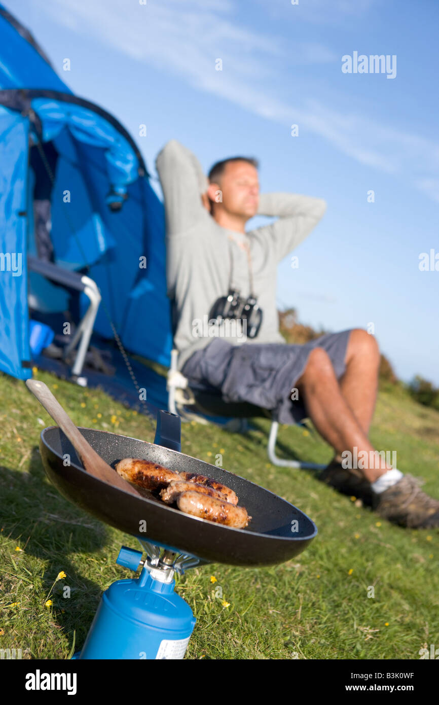 Man camping outdoors and cooking Stock Photo - Alamy