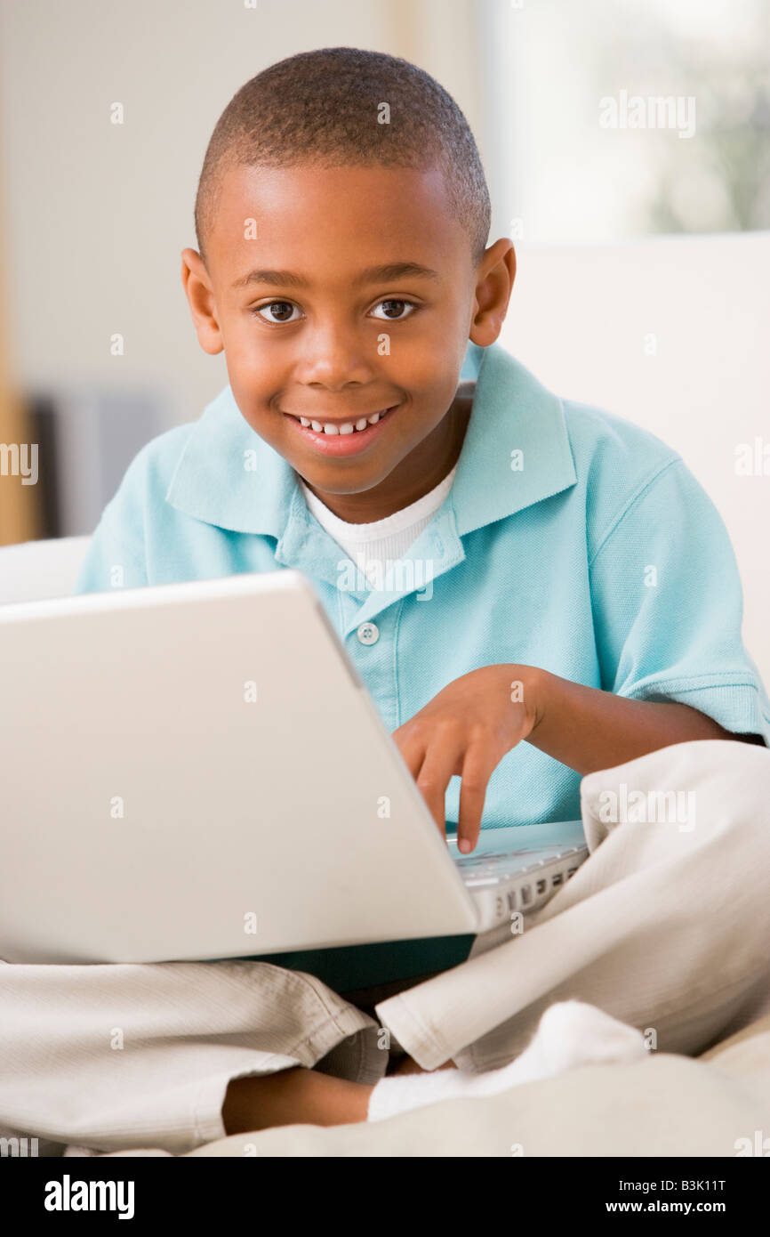 Young boy in living room with laptop smiling Stock Photo - Alamy