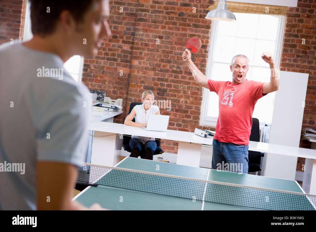 Two men in office space playing ping pong Stock Photo - Alamy