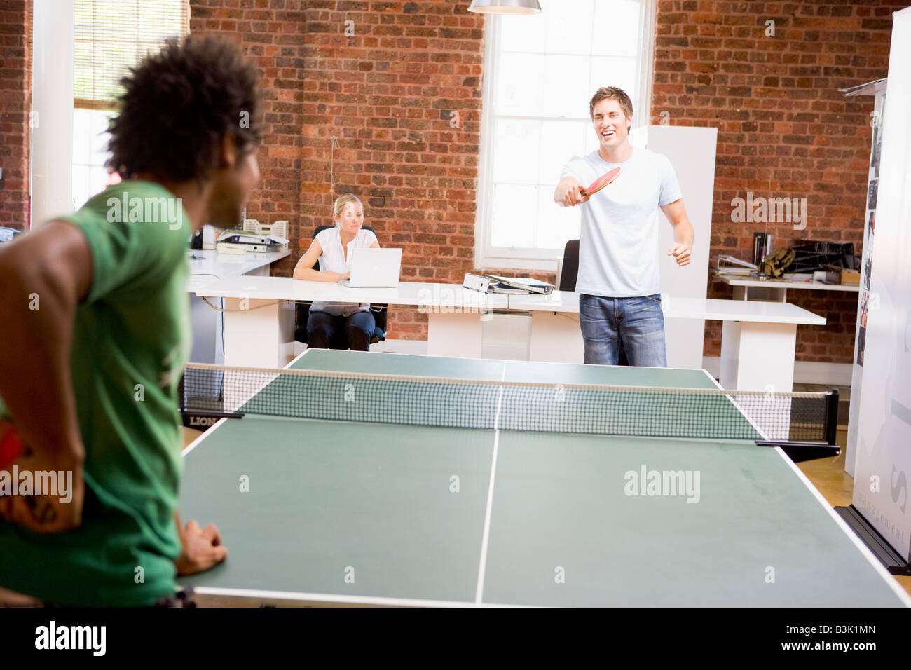 Two men in office space playing ping pong Stock Photo - Alamy