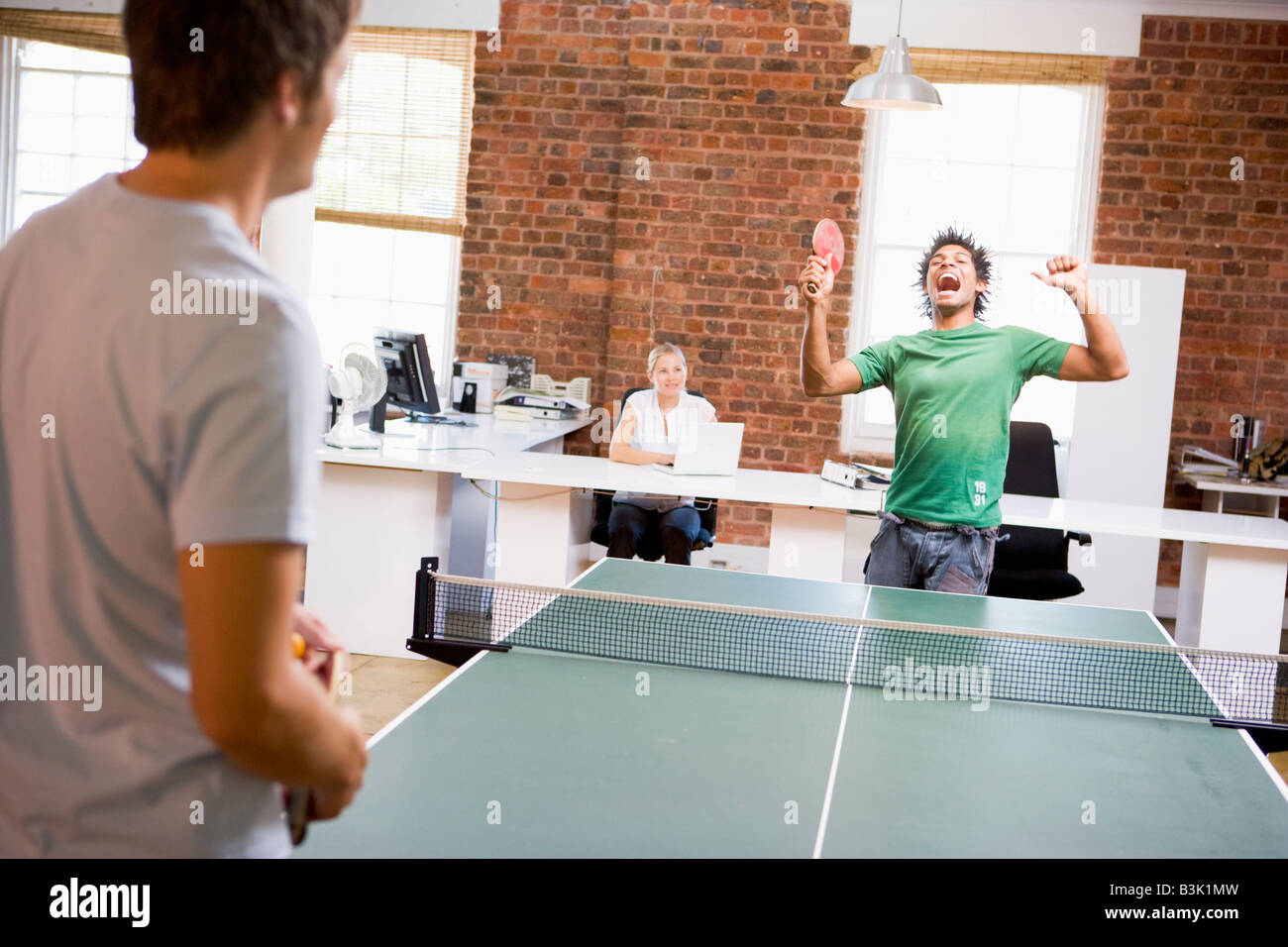 Two men in office space playing ping pong Stock Photo - Alamy