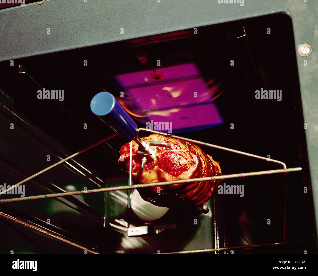 BEEF MEAT SPIT ROASTING IN GAS OVEN Stock Photo - Alamy
