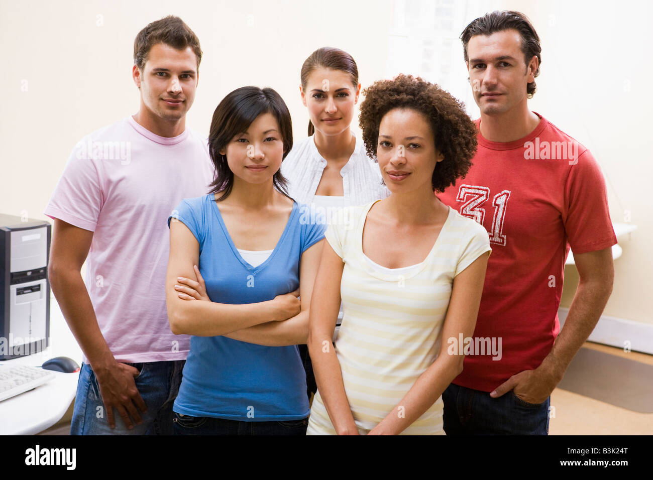 Five people standing in computer room Stock Photo - Alamy