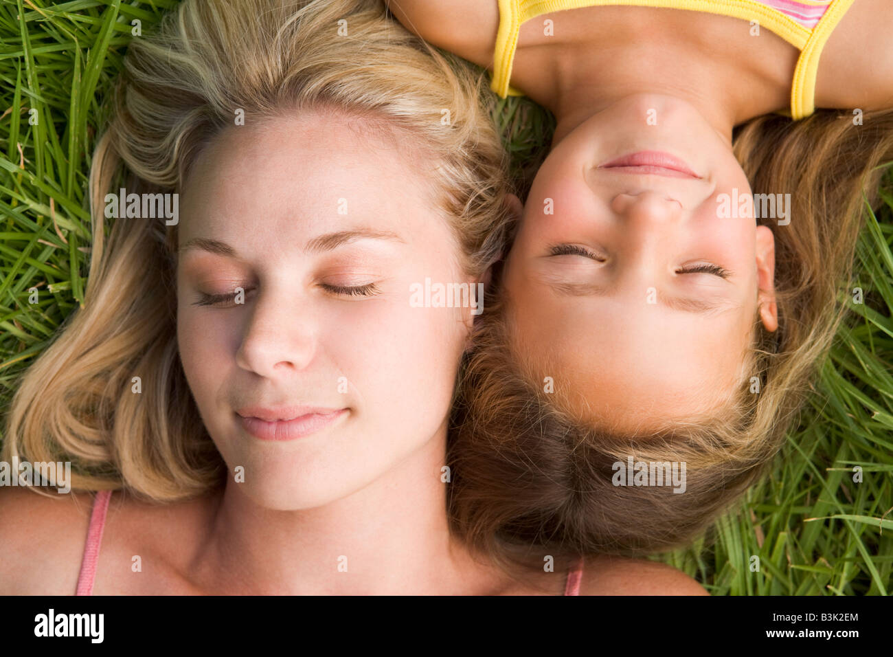 Woman and young girl lying in grass sleeping Stock Photo - Alamy