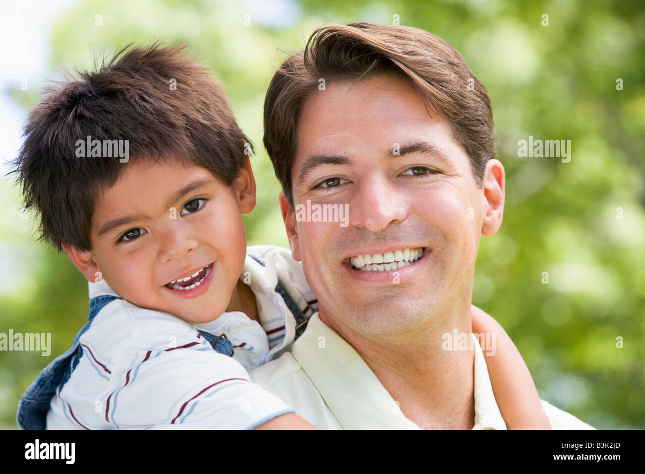 Man and young boy embracing outdoors smiling Stock Photo - Alamy