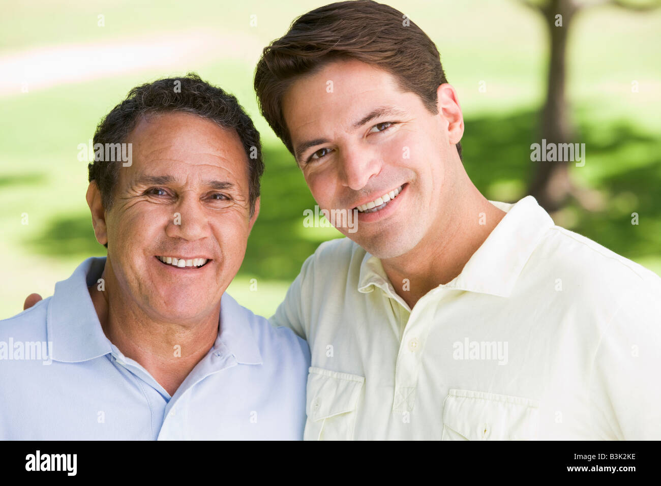 Two men standing outdoors smiling Stock Photo - Alamy