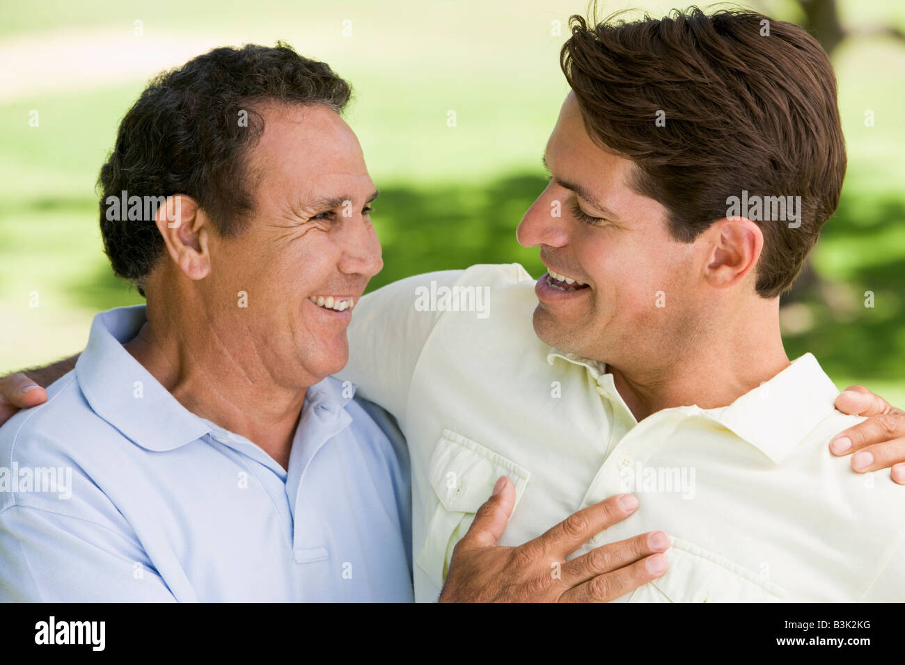 Two men standing outdoors bonding and smiling Stock Photo - Alamy