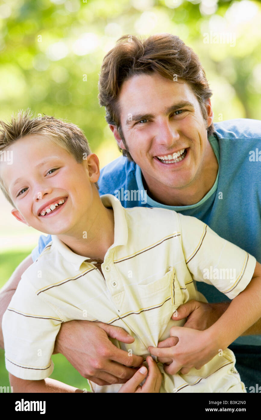Man and young boy outdoors embracing and smiling Stock Photo - Alamy