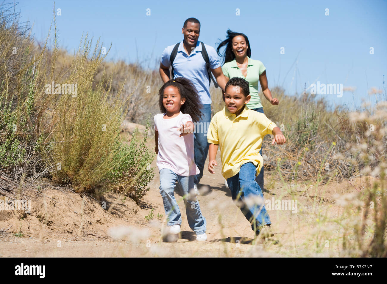 Family running on path smiling Stock Photo - Alamy
