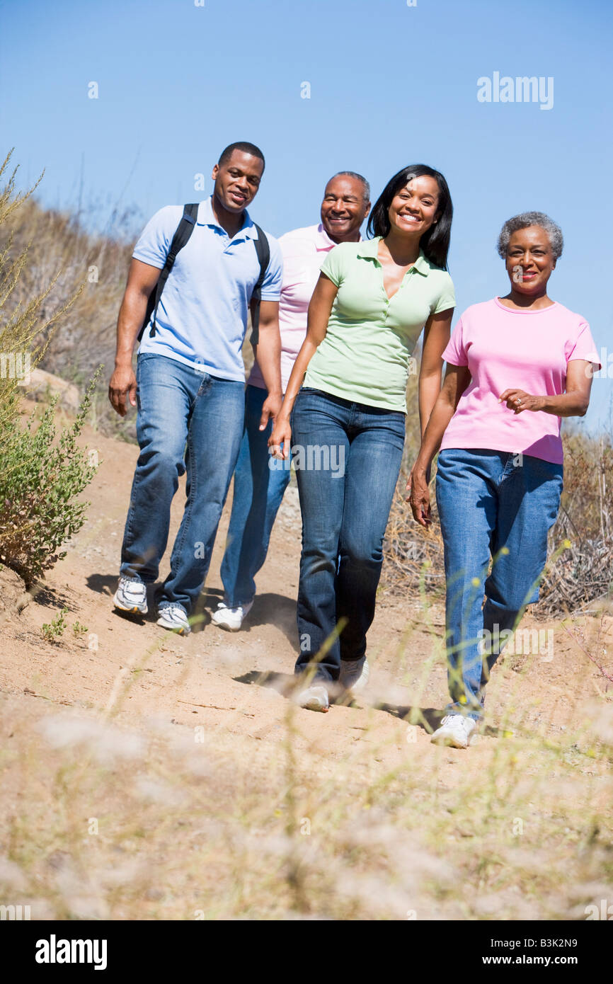 Two couples walking on path smiling Stock Photo - Alamy