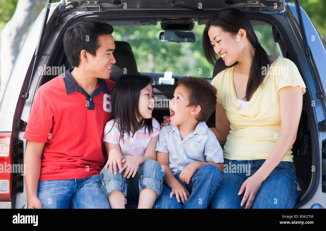 Family sitting in back of van smiling Stock Photo - Alamy