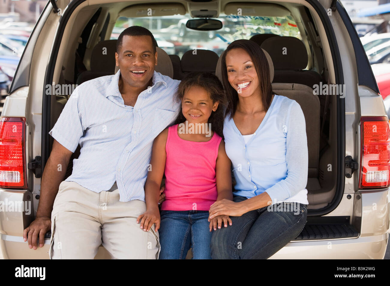 Family sitting in back of van smiling Stock Photo - Alamy