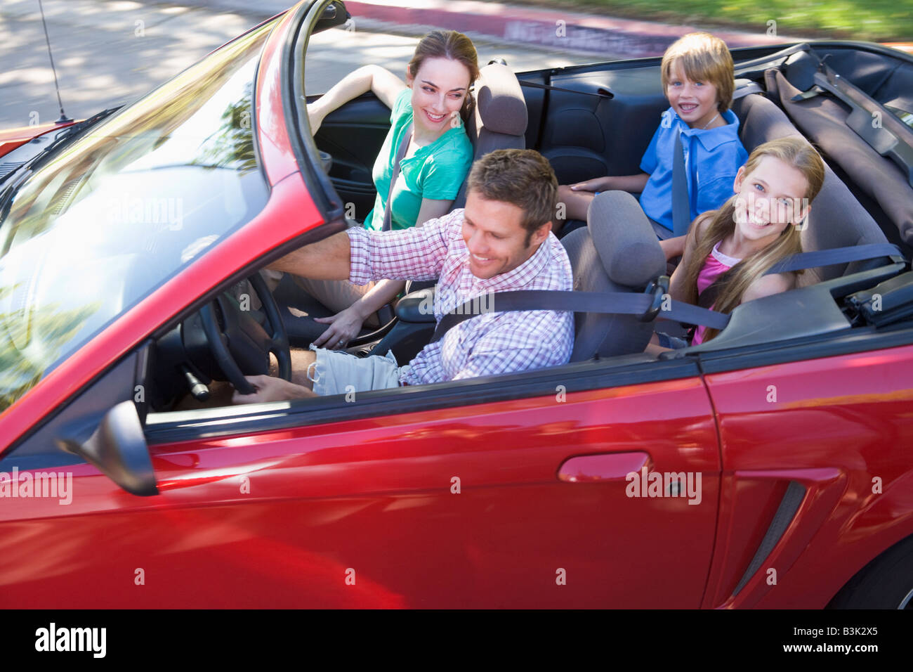 Family in convertible car smiling Stock Photo - Alamy