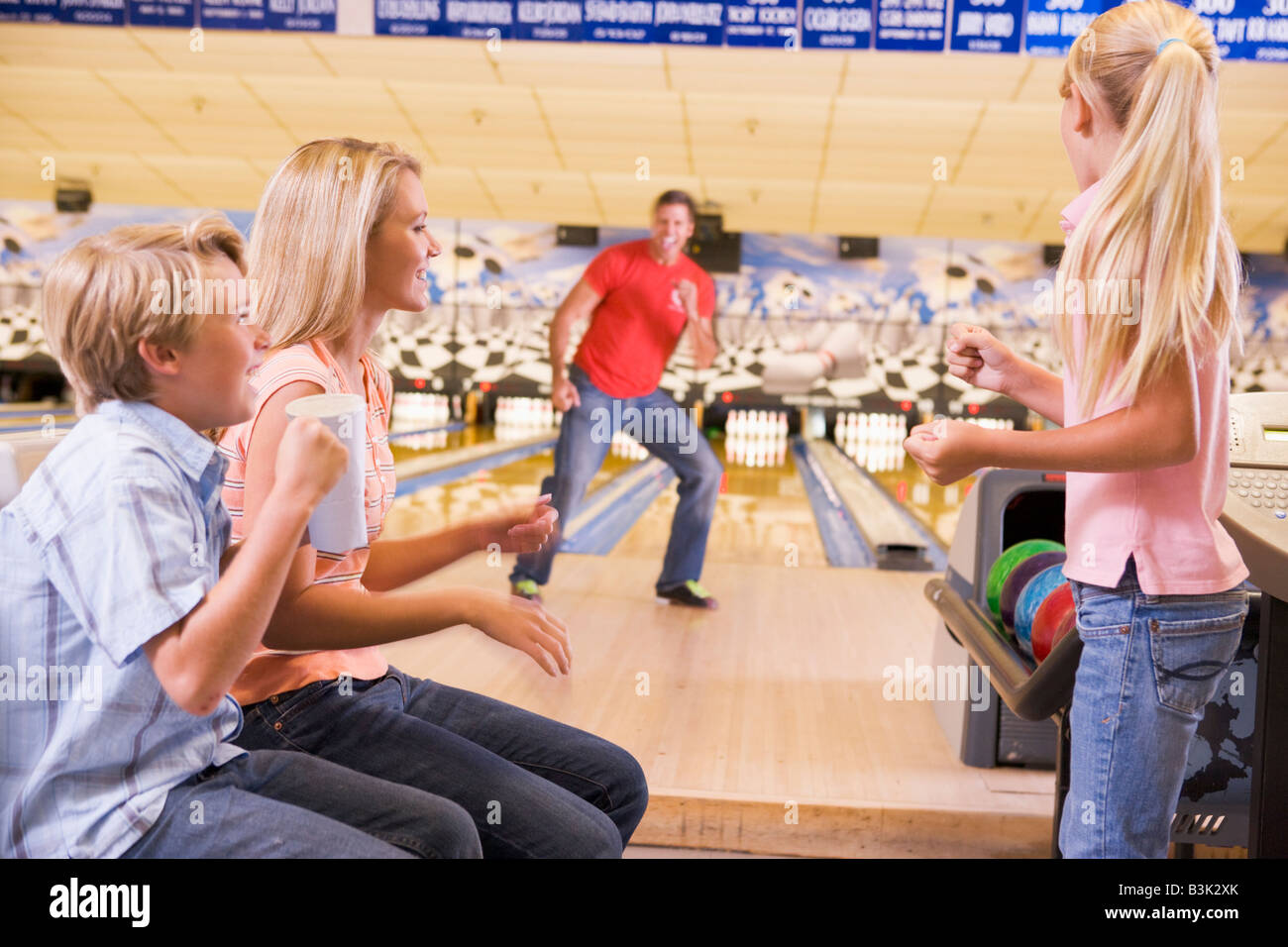 Family in bowling alley smiling Stock Photo - Alamy