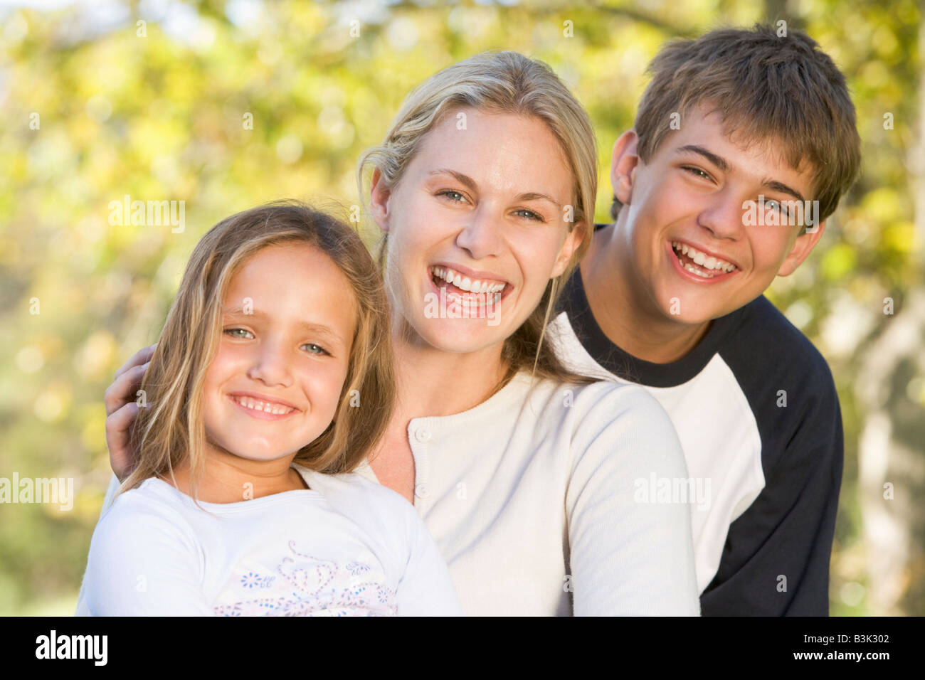 Woman with two young children outdoors smiling Stock Photo - Alamy