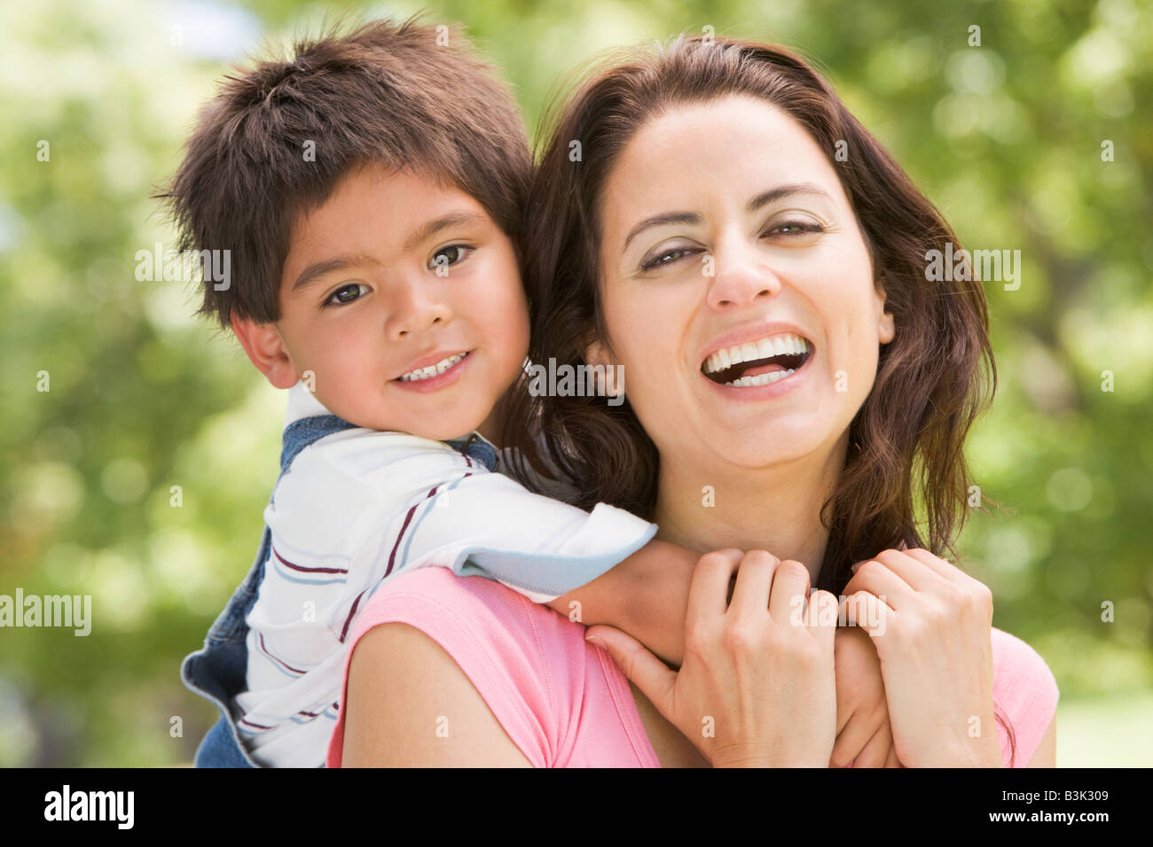 Woman and young boy outdoors embracing and smiling Stock Photo - Alamy