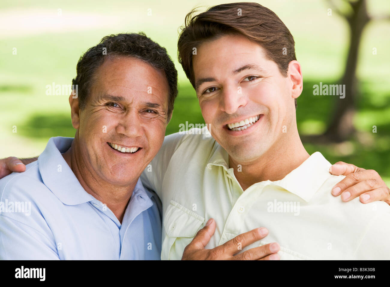 Two men outdoors embracing and smiling Stock Photo - Alamy