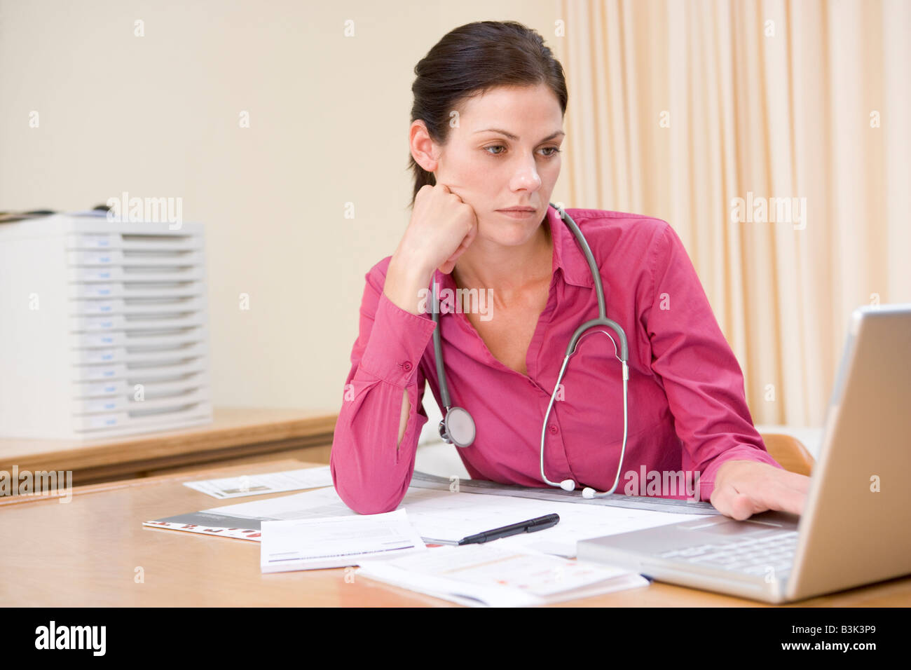 Tired doctor using laptop hi-res stock photography and images - Alamy