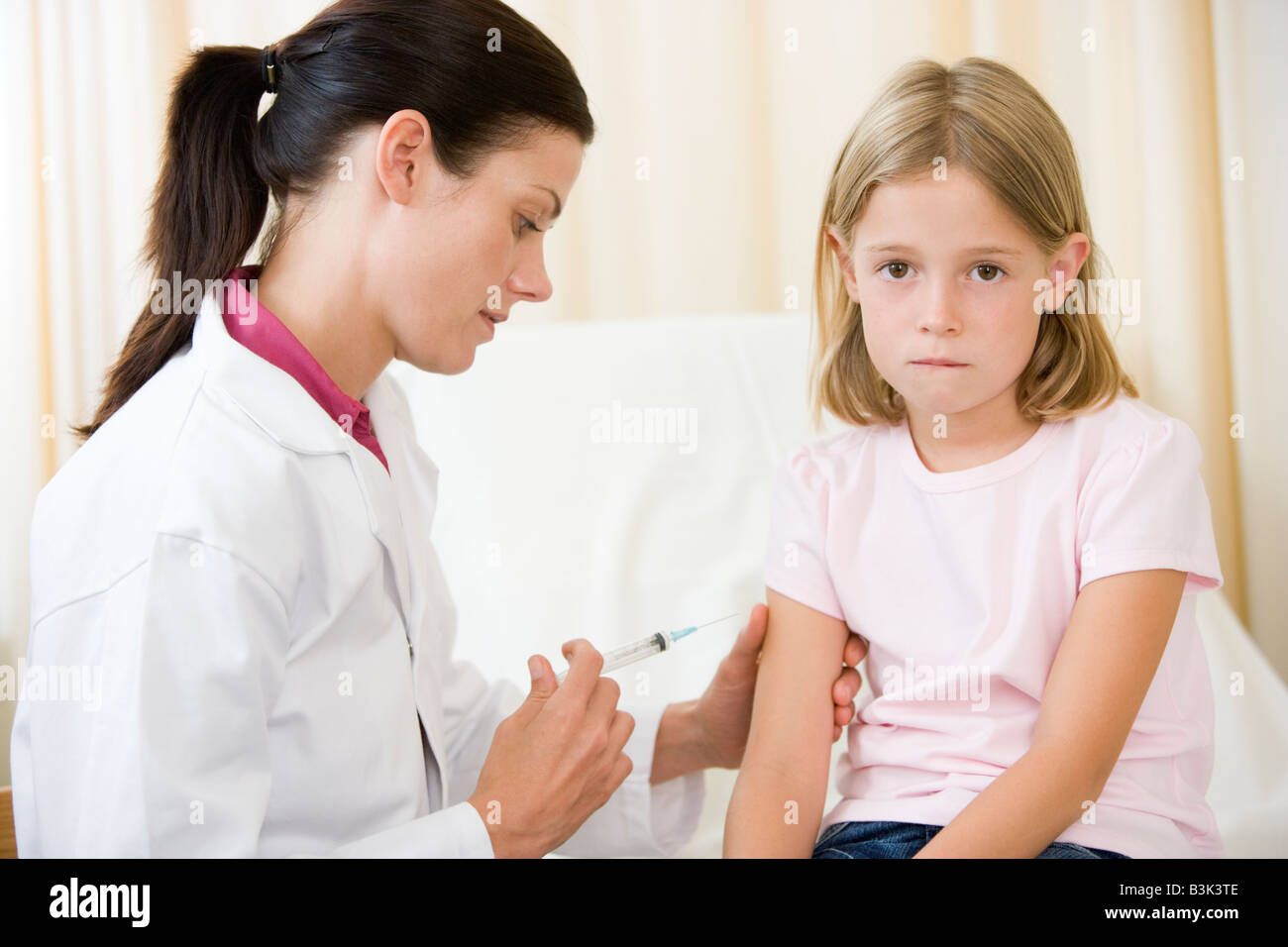 Doctor giving needle to young girl in exam room Stock Photo - Alamy