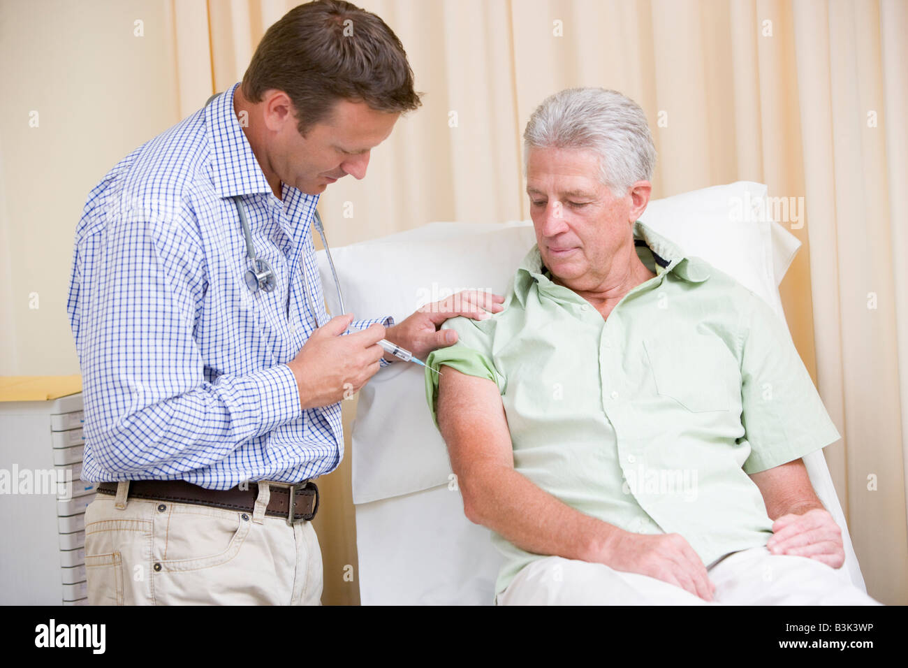 Doctor giving man needle in exam room Stock Photo - Alamy