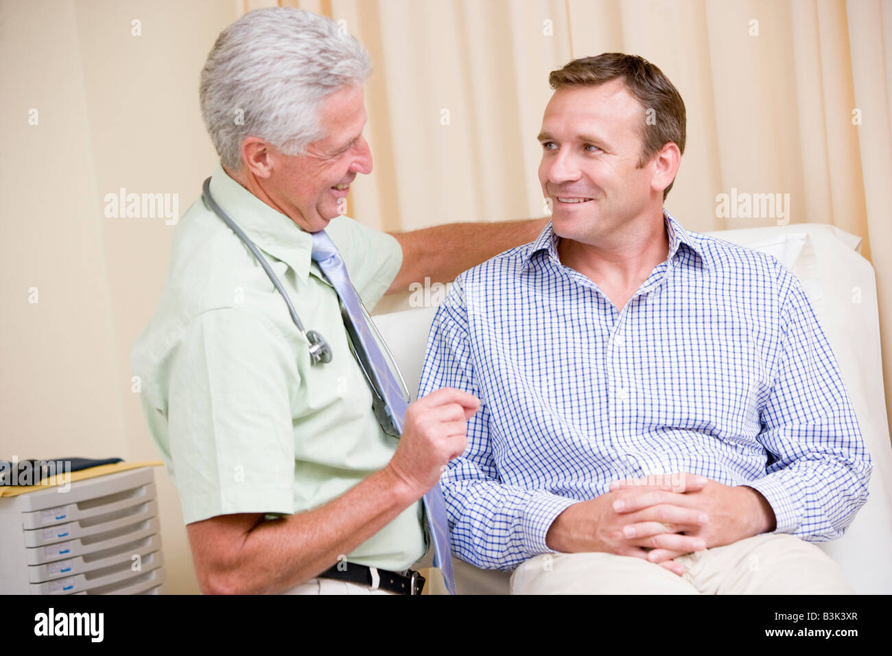 Doctor giving smiling man checkup in exam room Stock Photo - Alamy