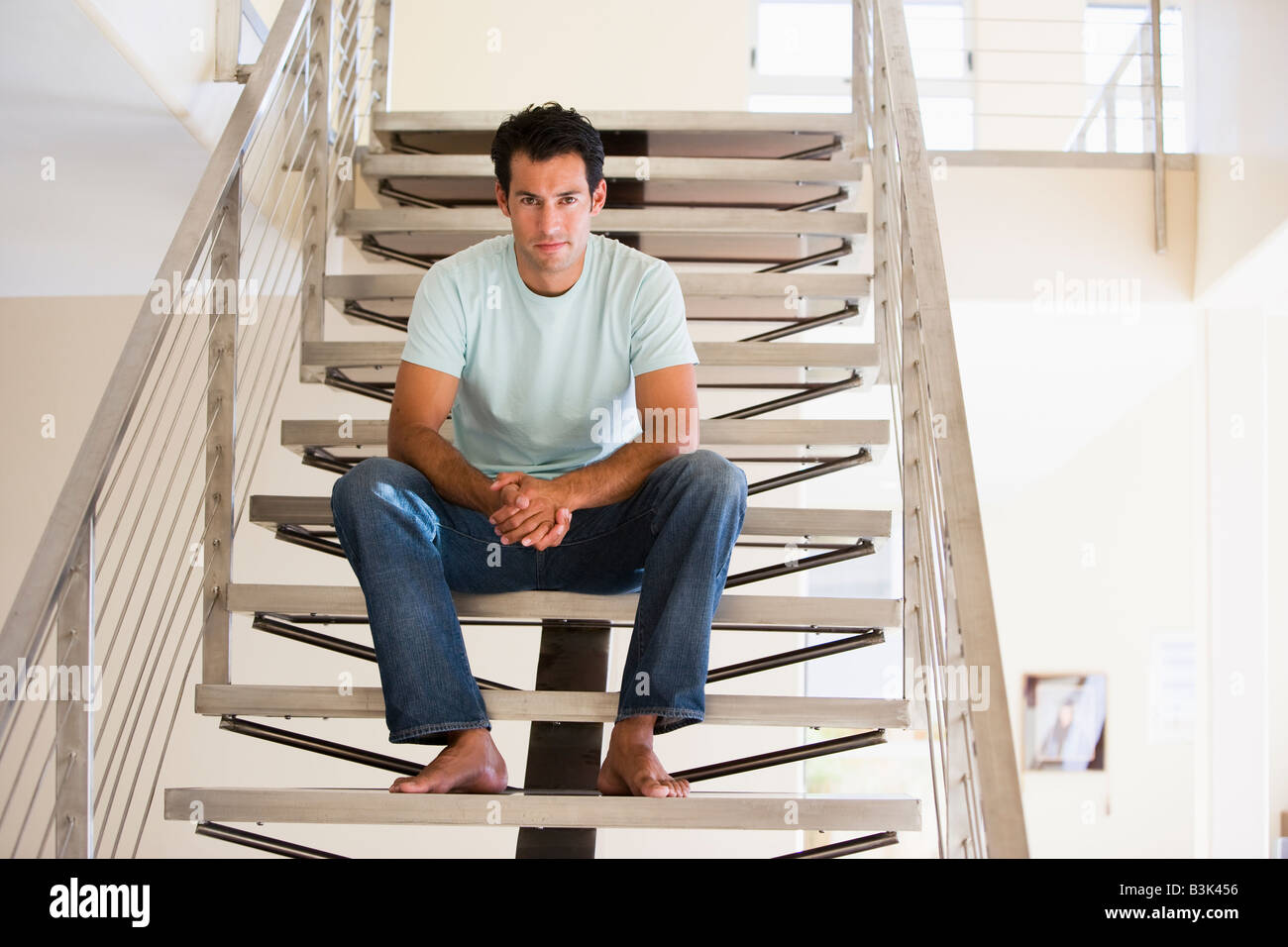 Man sitting on staircase Stock Photo - Alamy