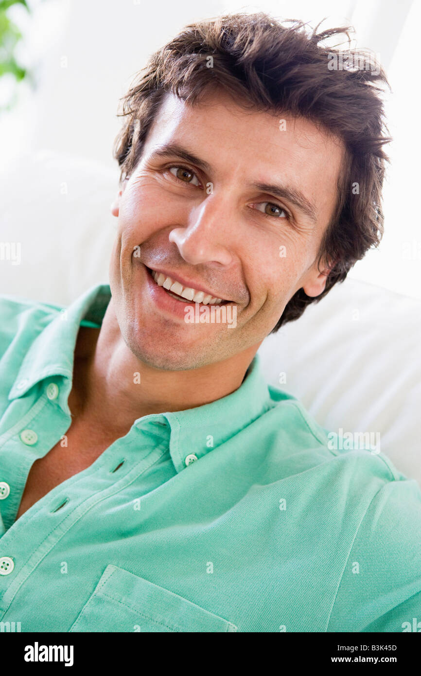 Man sitting in living room smiling Stock Photo - Alamy
