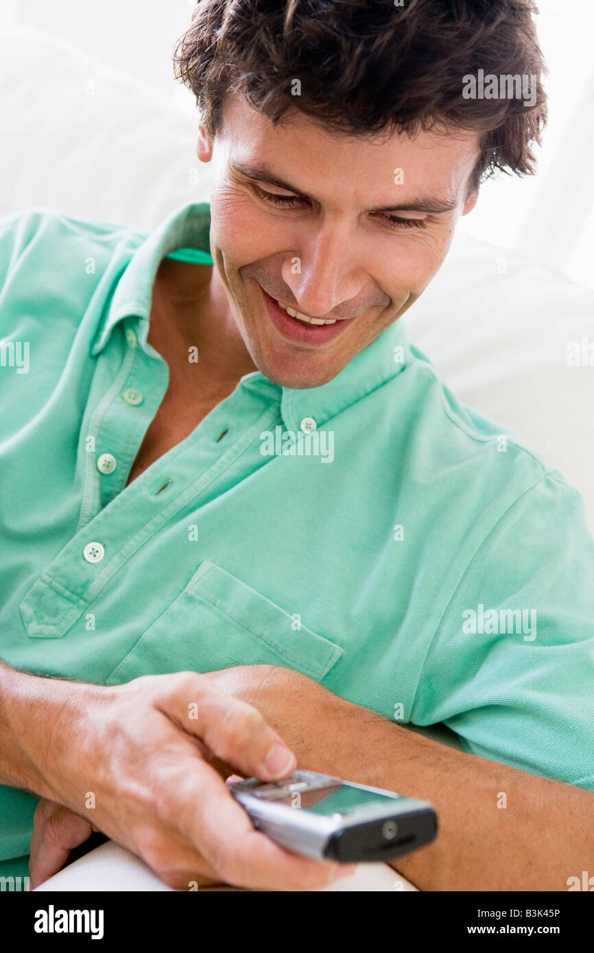 Man indoors text messaging Stock Photo - Alamy